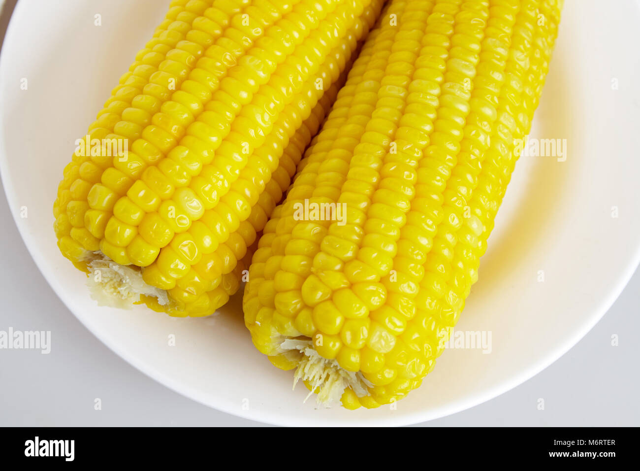 Steamed corns (boiled corns) on the white plate, white background ...