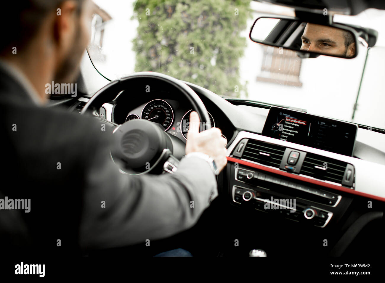 Back view of an handsome smiling business man driving his car Stock ...