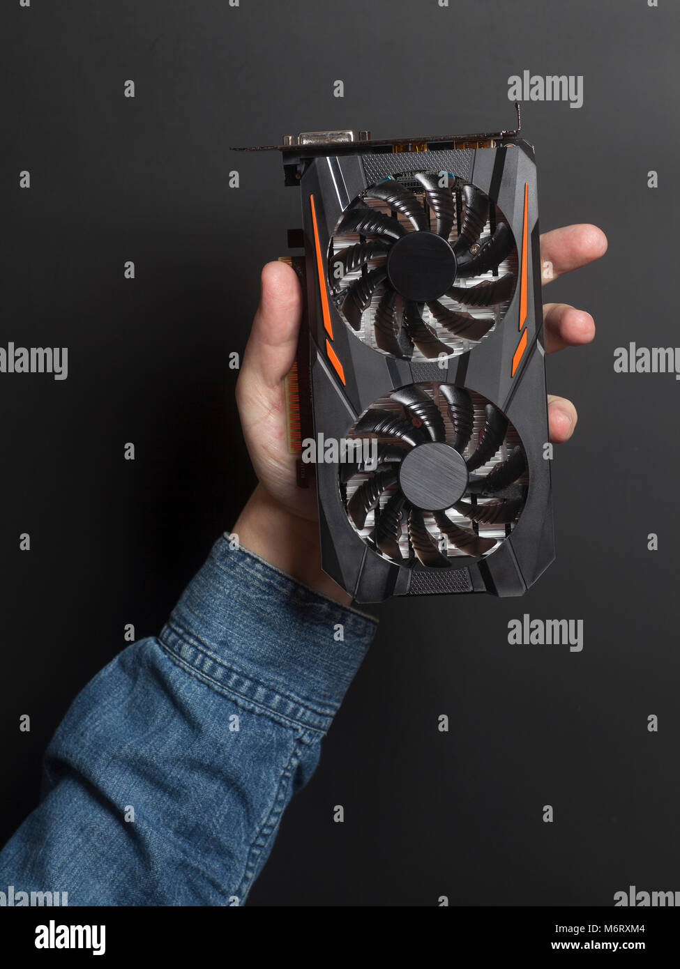 Graphic video card holding hand on black background Stock Photo - Alamy