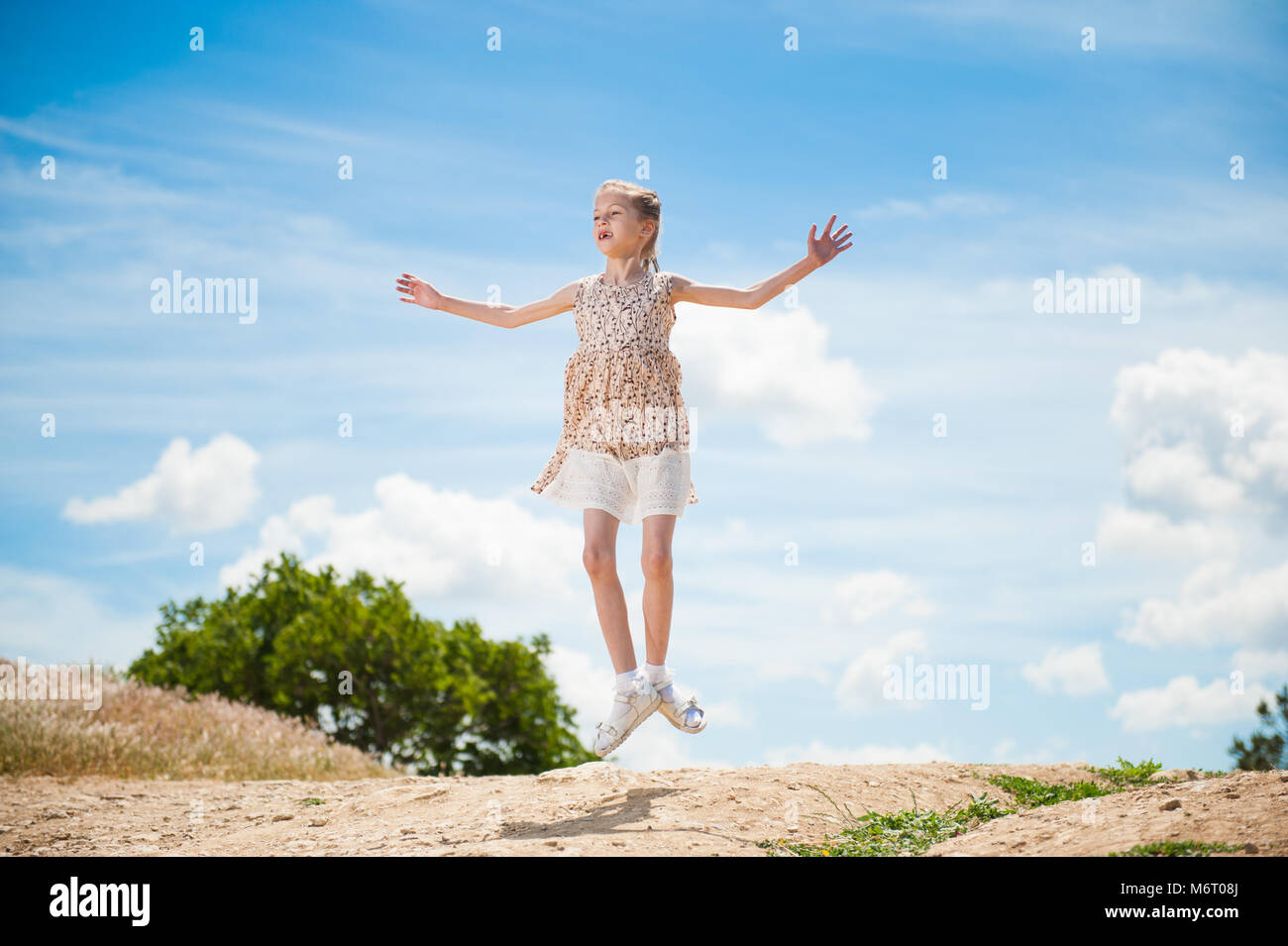 skinny dancer girl in dress jumping high against blue sky in summer ...
