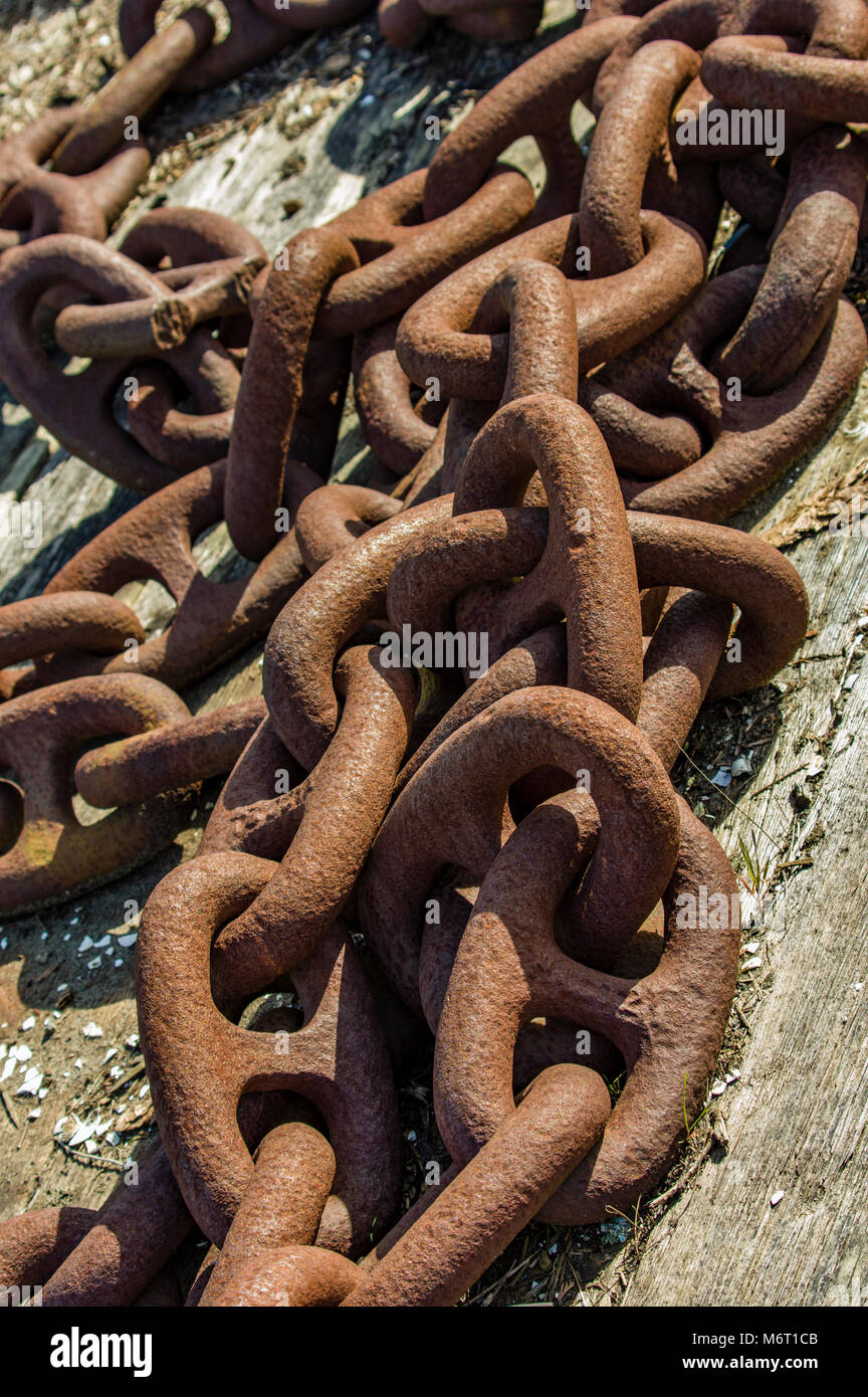 Rusty anchor chain on a wooden dock Stock Photo - Alamy