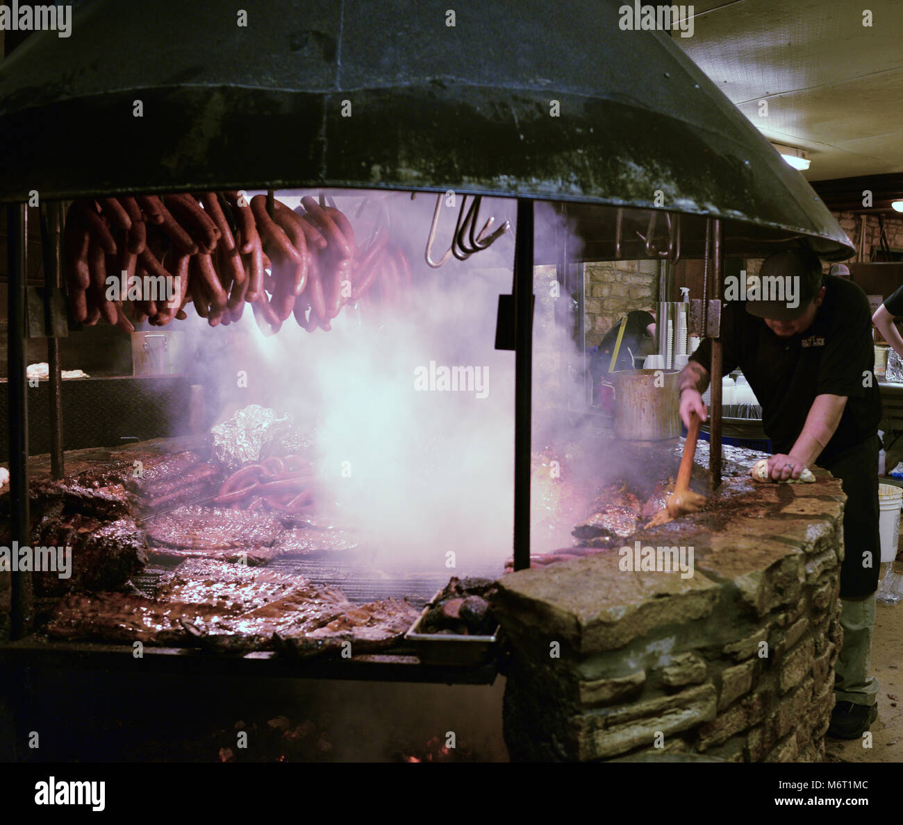 Meat smoking in open pit for bar-b-que Stock Photo - Alamy