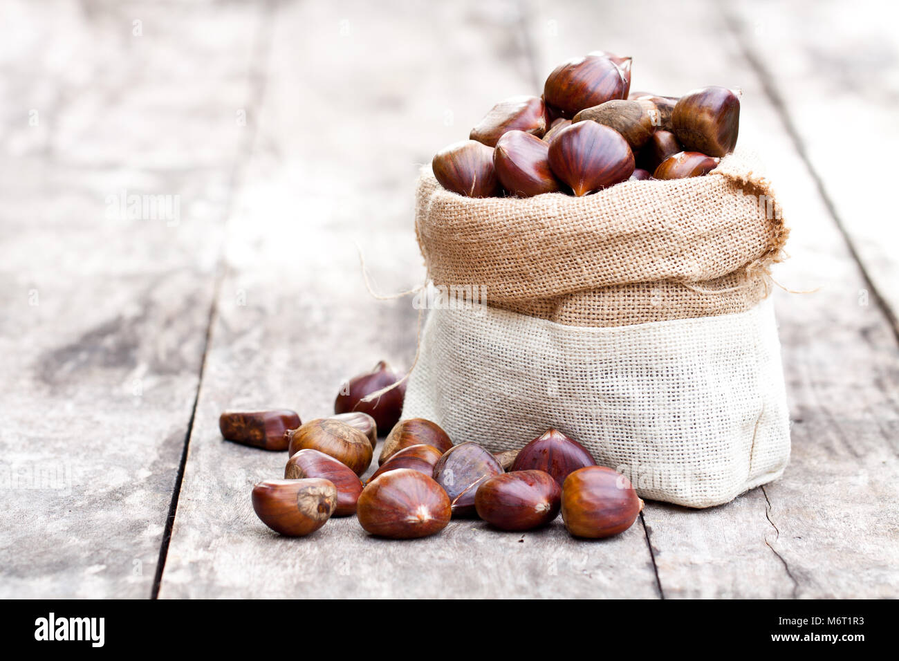 fresh chestnuts in sack bag on the old wooden table Stock Photo - Alamy