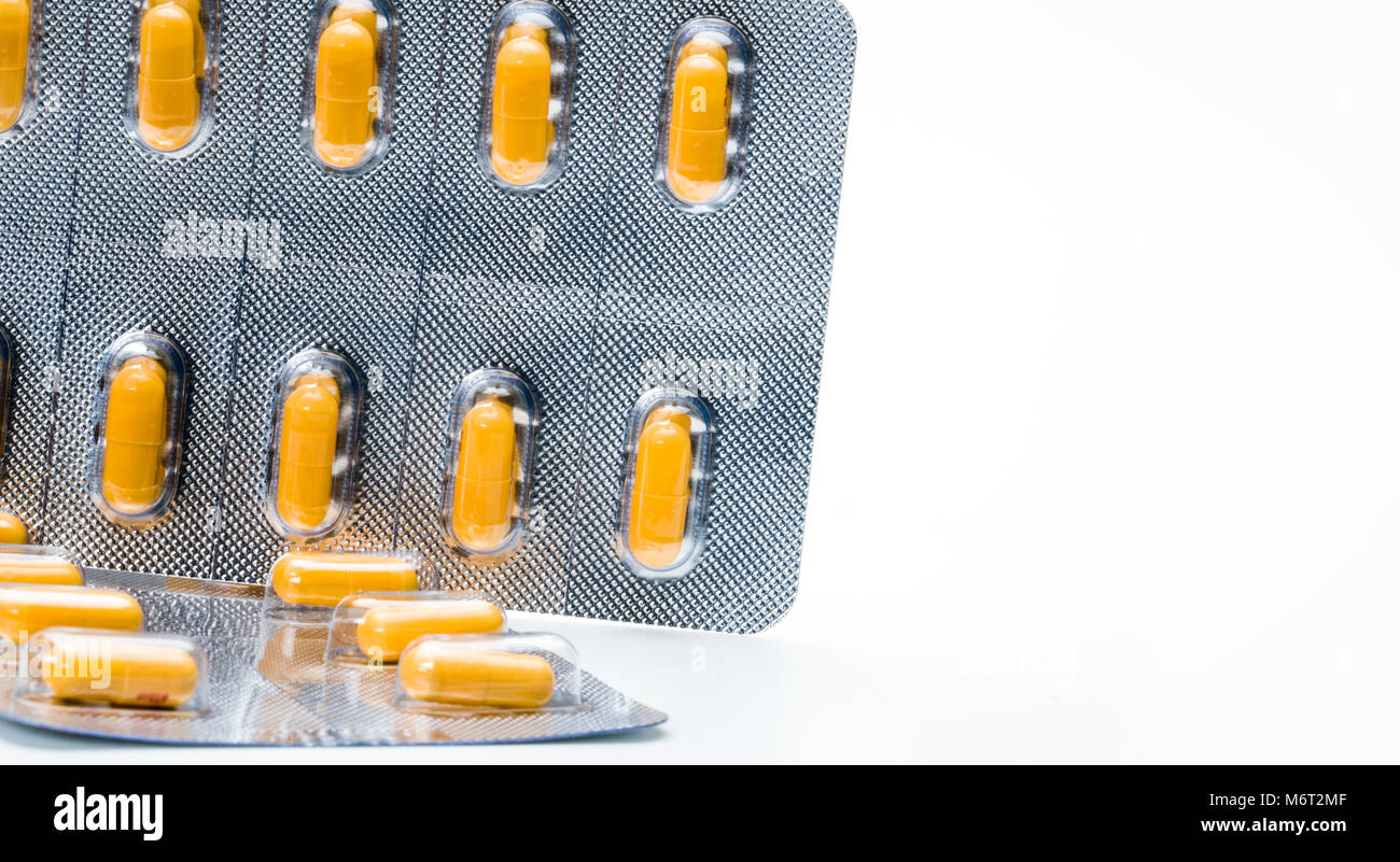 Orange capsule pills in blister pack isolated on white background with ...