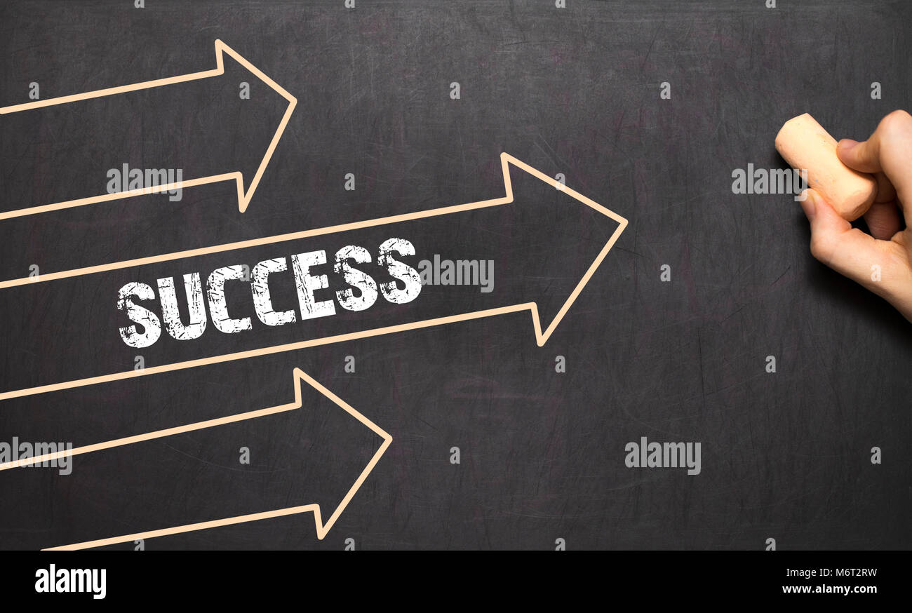 A businessman is drawing Success concept with arrows on blackboard ...
