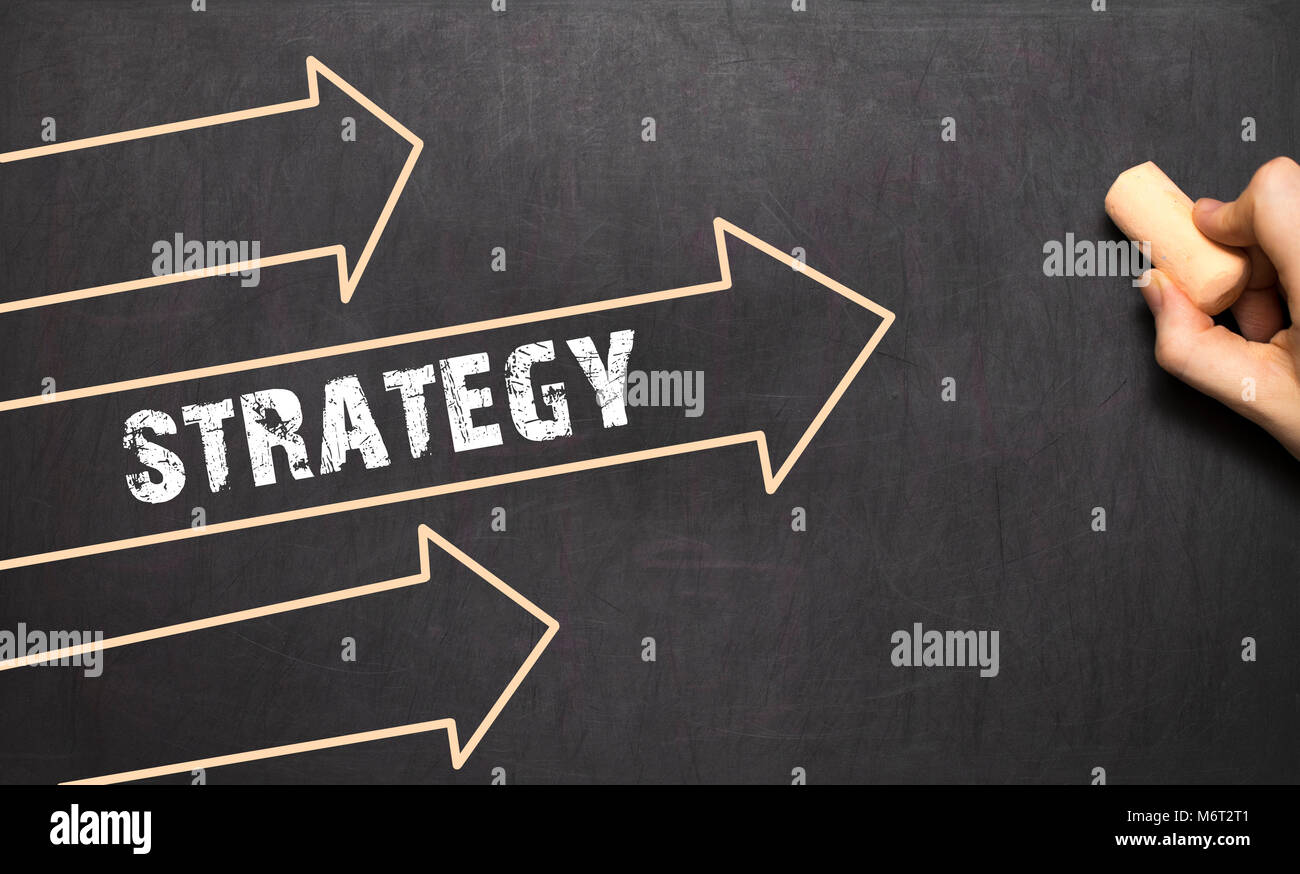 A businessman is drawing strategy concept with arrows on blackboard ...