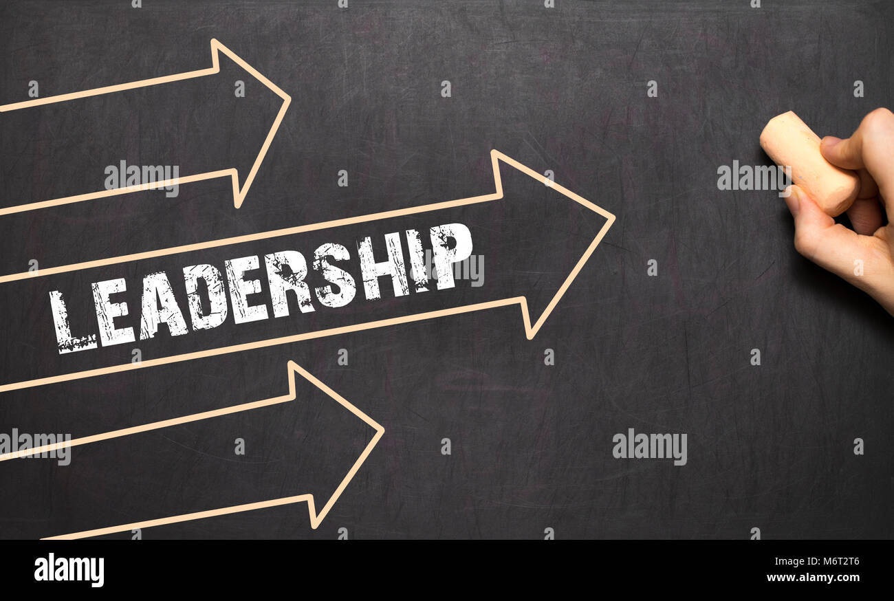 A businessman is drawing Leadership concept with arrows on blackboard ...