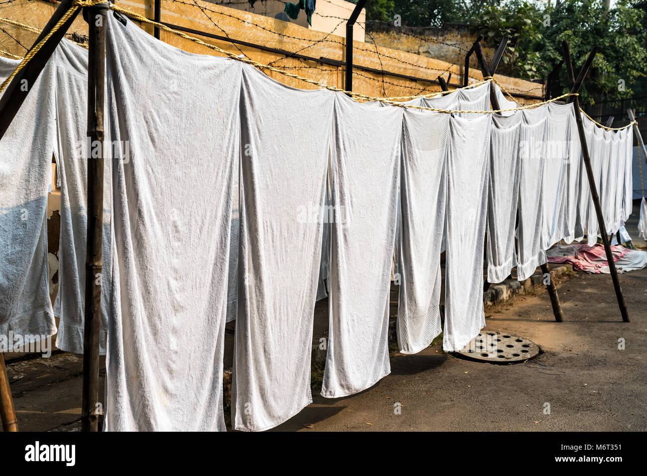 White sheets hang on ropes in Indian street Stock Photo - Alamy