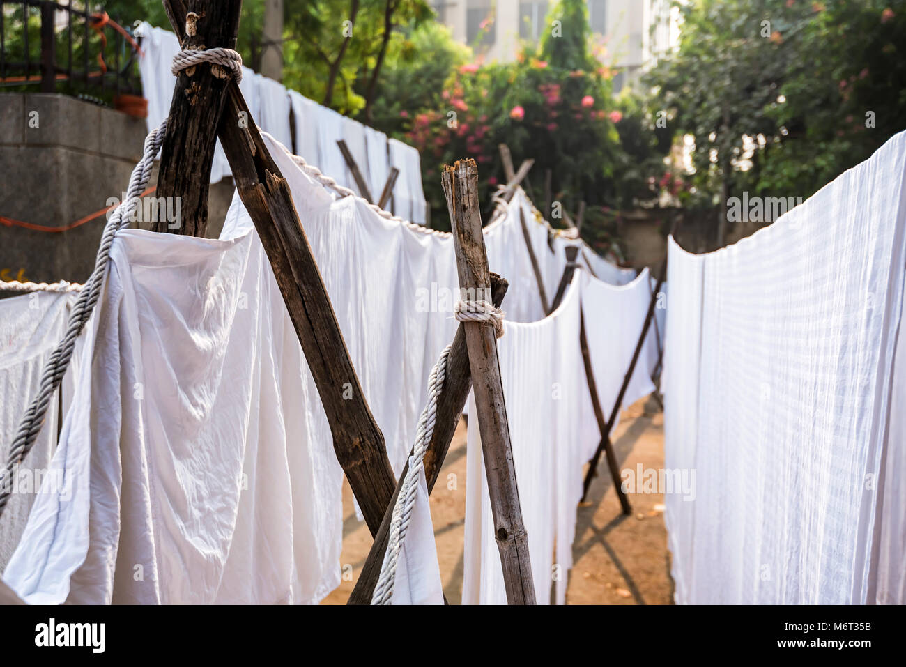 White sheets hang on ropes in Indian street Stock Photo - Alamy