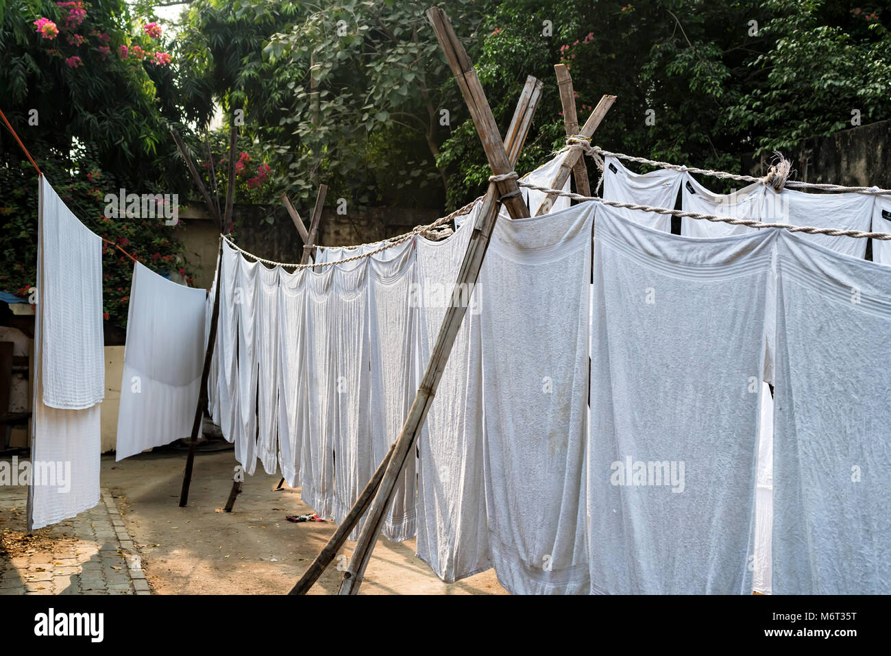 White sheets hang on ropes in Indian street Stock Photo - Alamy
