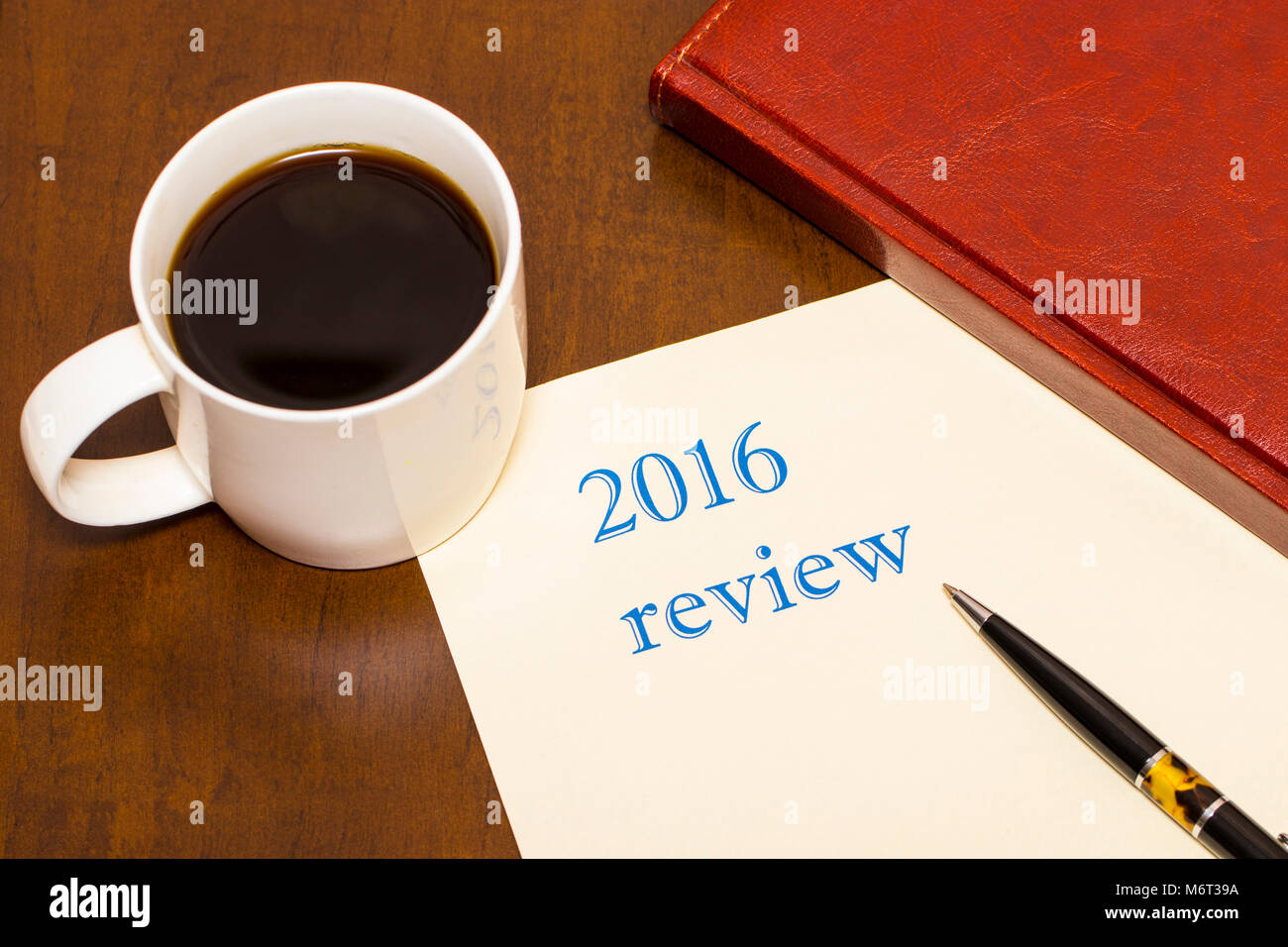 The 2016 review the text on the sheet of paper next to a Cup of coffee ...