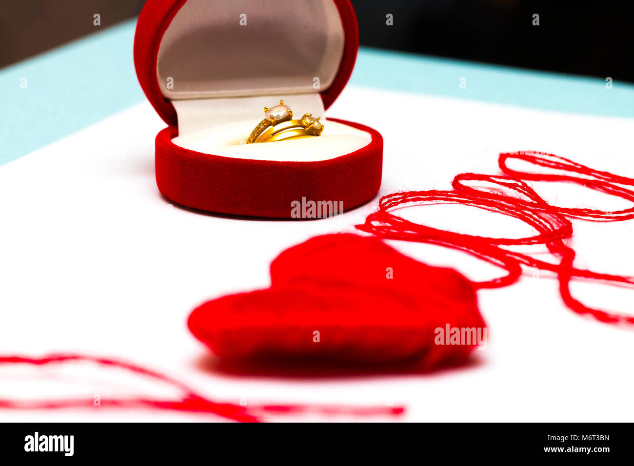 Love you words and heart symbol made of red thread on a white ...