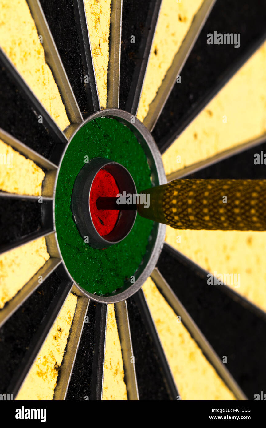 Dart arrow hitting in the target center of dartboard Stock Photo - Alamy