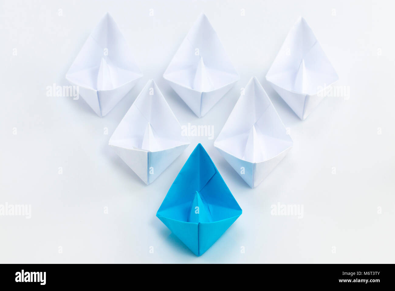 Leadership concept using blue paper ship among white Stock Photo - Alamy