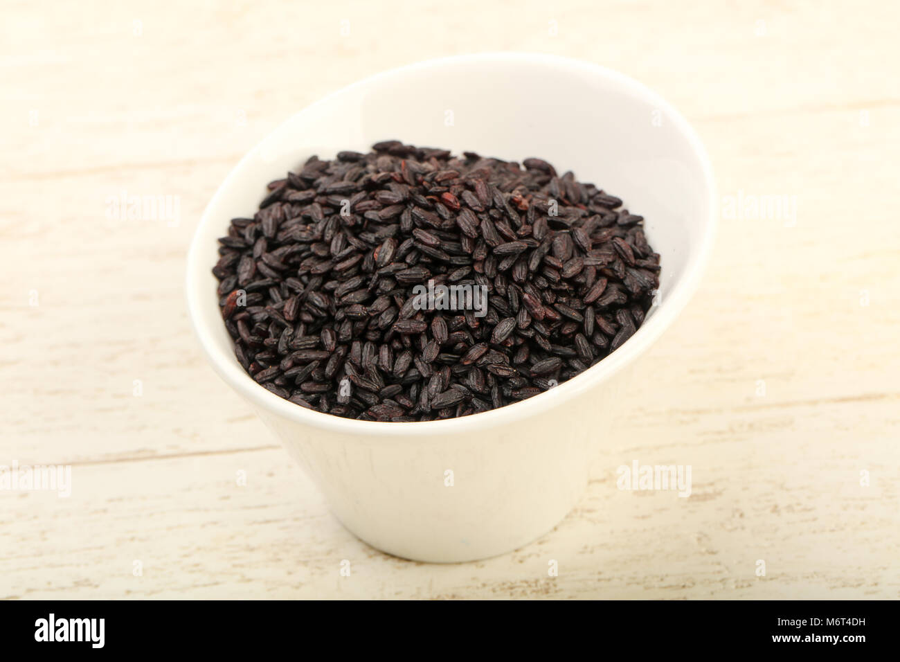 Black wild rice in the bowl over wooden background Stock Photo - Alamy