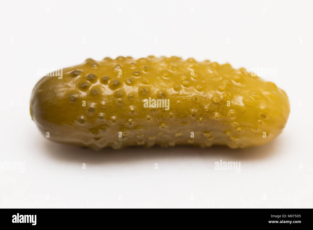 One pickled cucumber cut in half on white background Stock Photo - Alamy