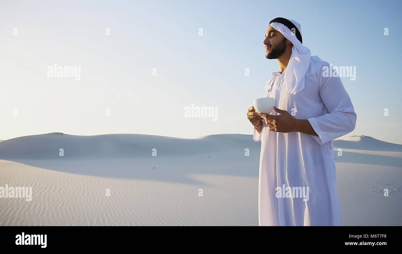 Portrait of handsome young Arabian Sheikh who drinks from cup of Stock ...