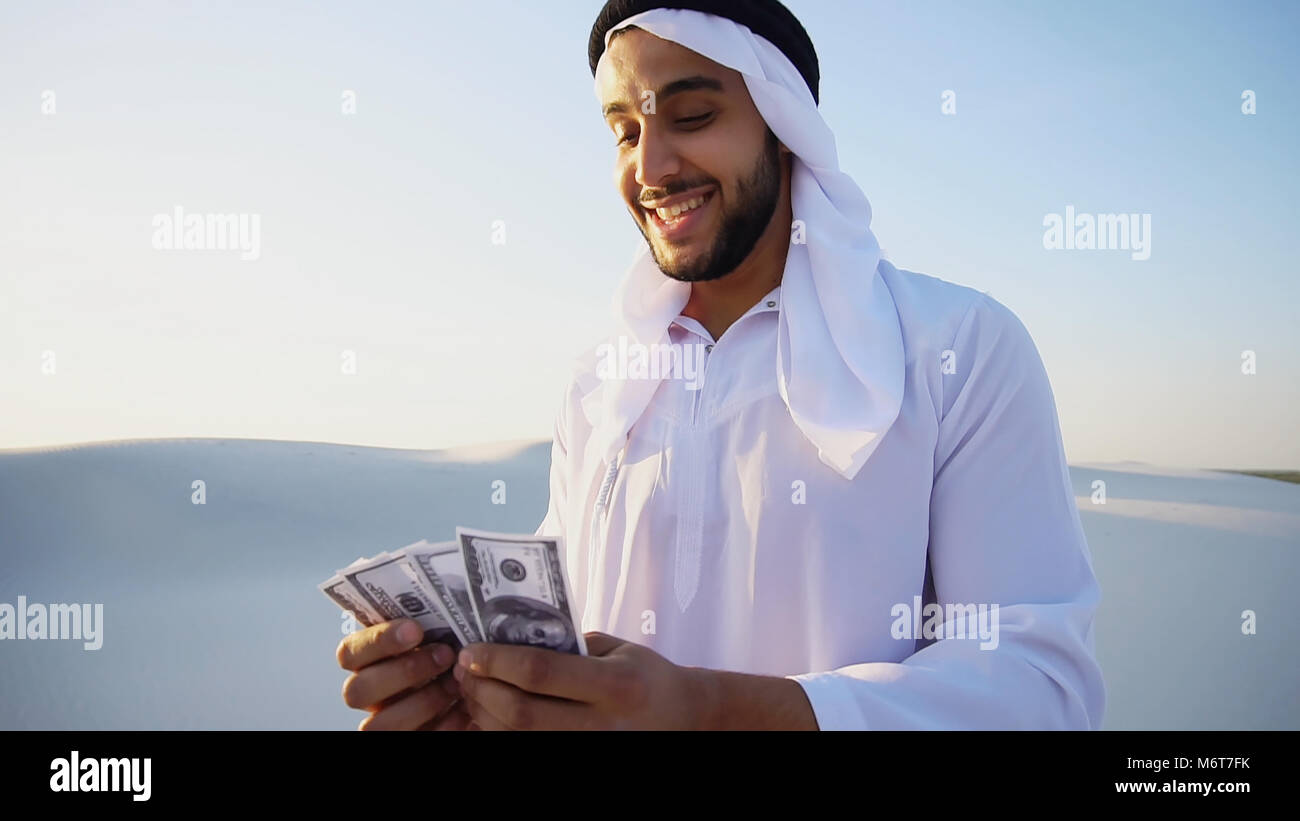 Successful Arab sheikh considers banknotes and happy, standing i Stock ...