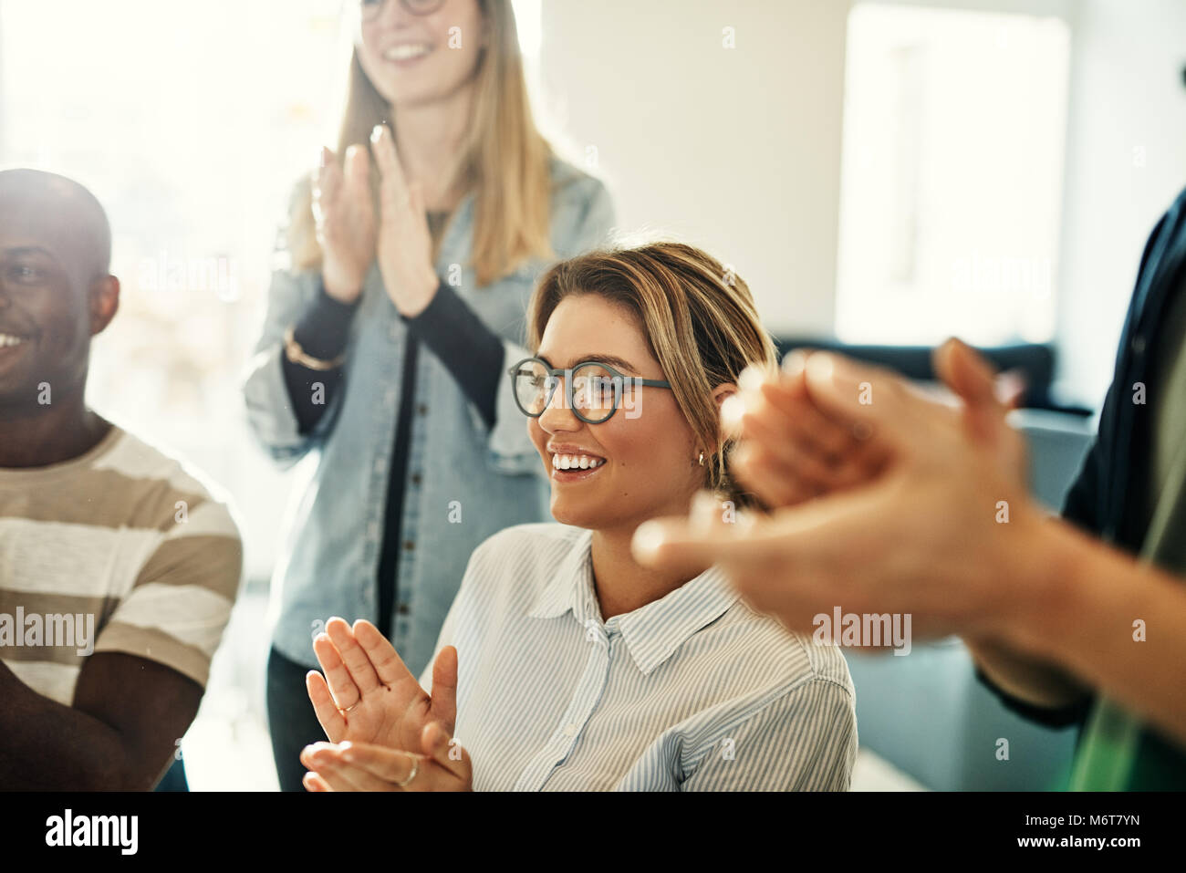 Smiling group of diverse work colleagues sitting together in a modern ...