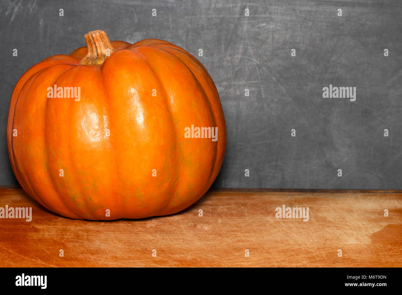 autumn pumpkin on the classroom table in front of a blackboard Stock ...