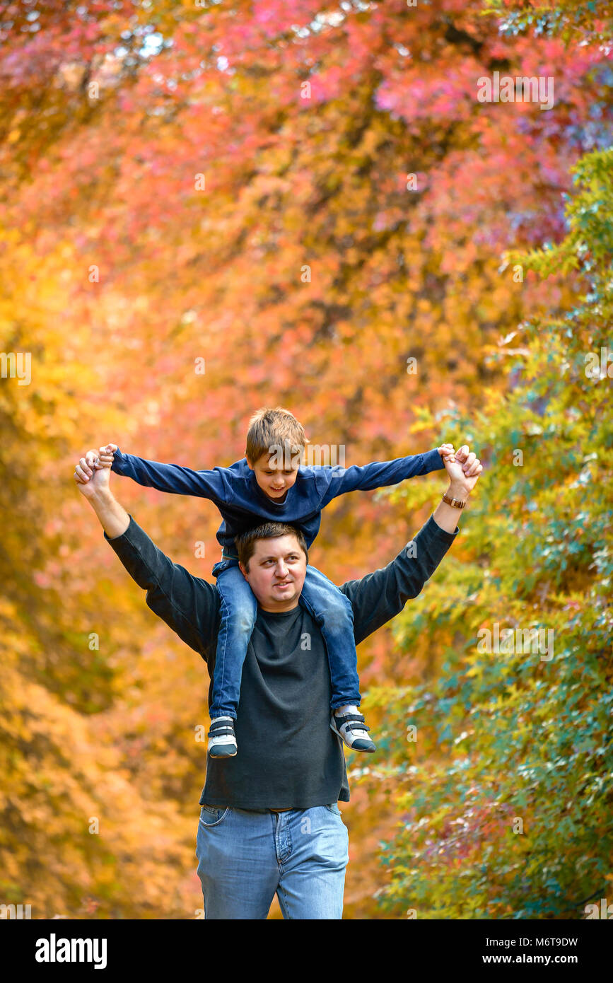 Father giving son piggyback ride in the autumn park Stock Photo - Alamy