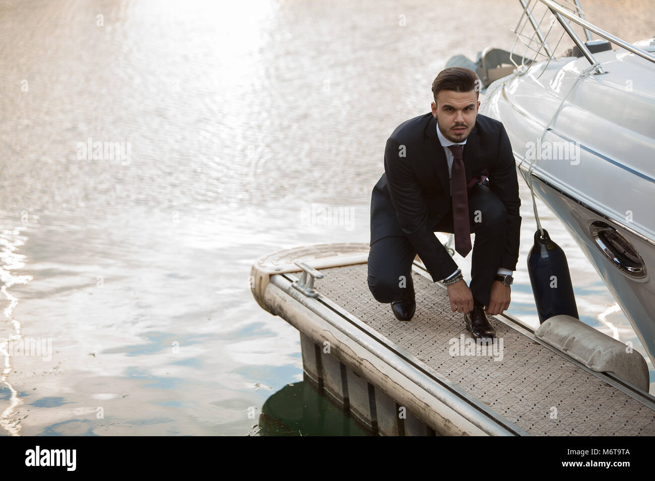 Men with suit and tie chilling in a port with boat Stock Photo - Alamy