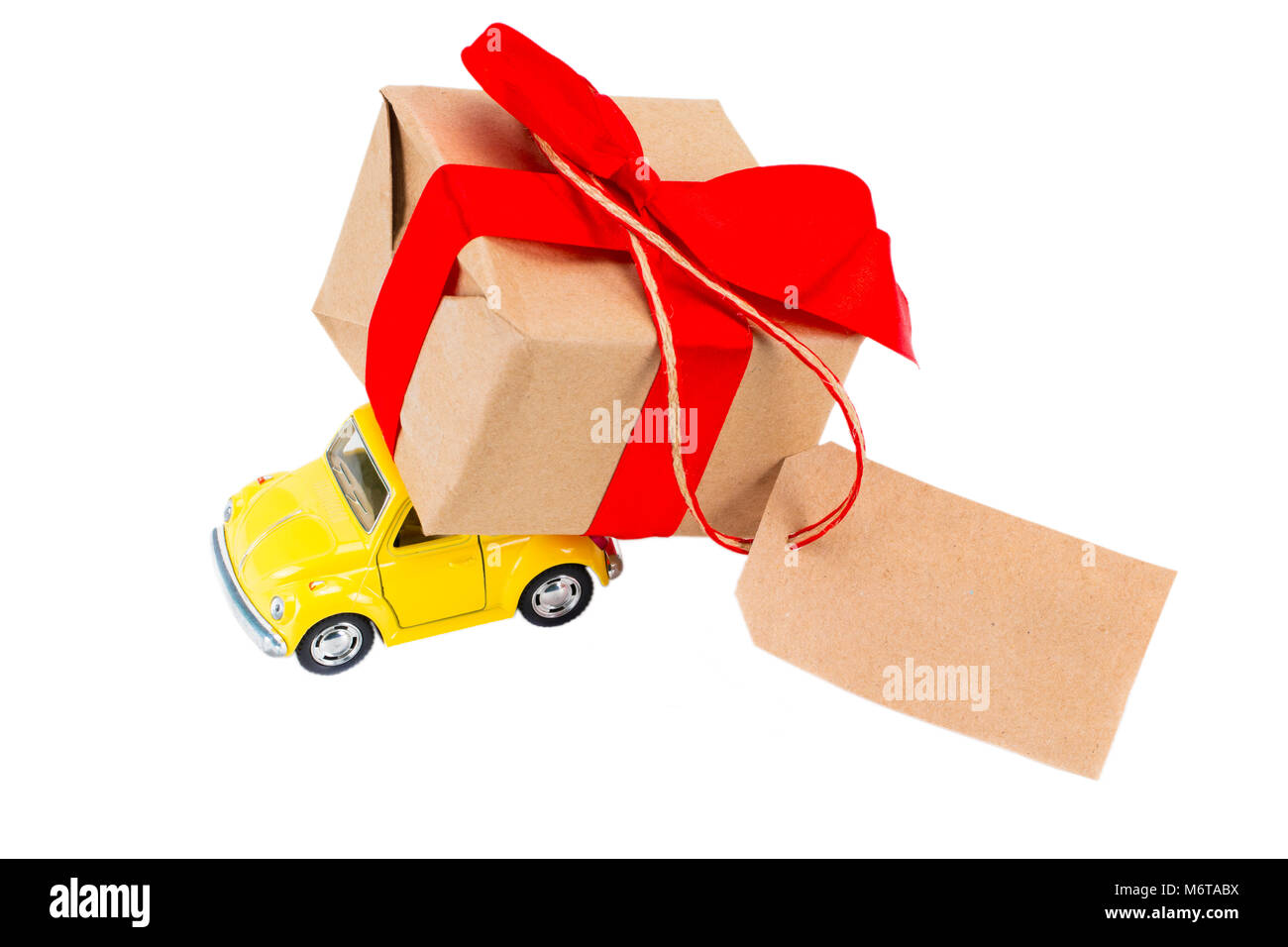 The Yellow retro toy car delivering gifts box with tag with empty space ...