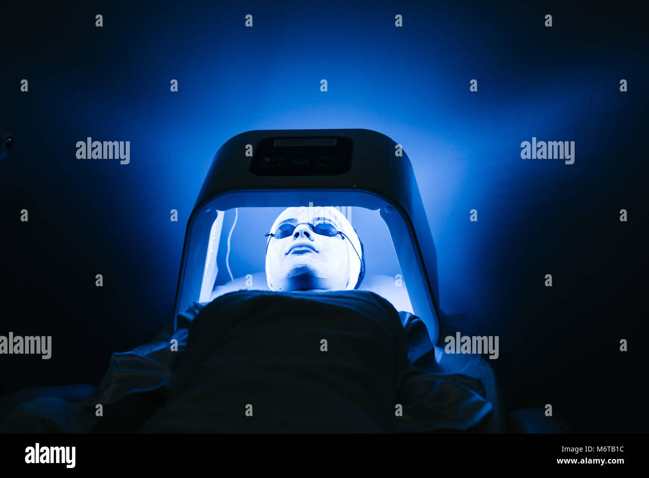 Woman with mack and solarium glassses on her face is tanning in the ...