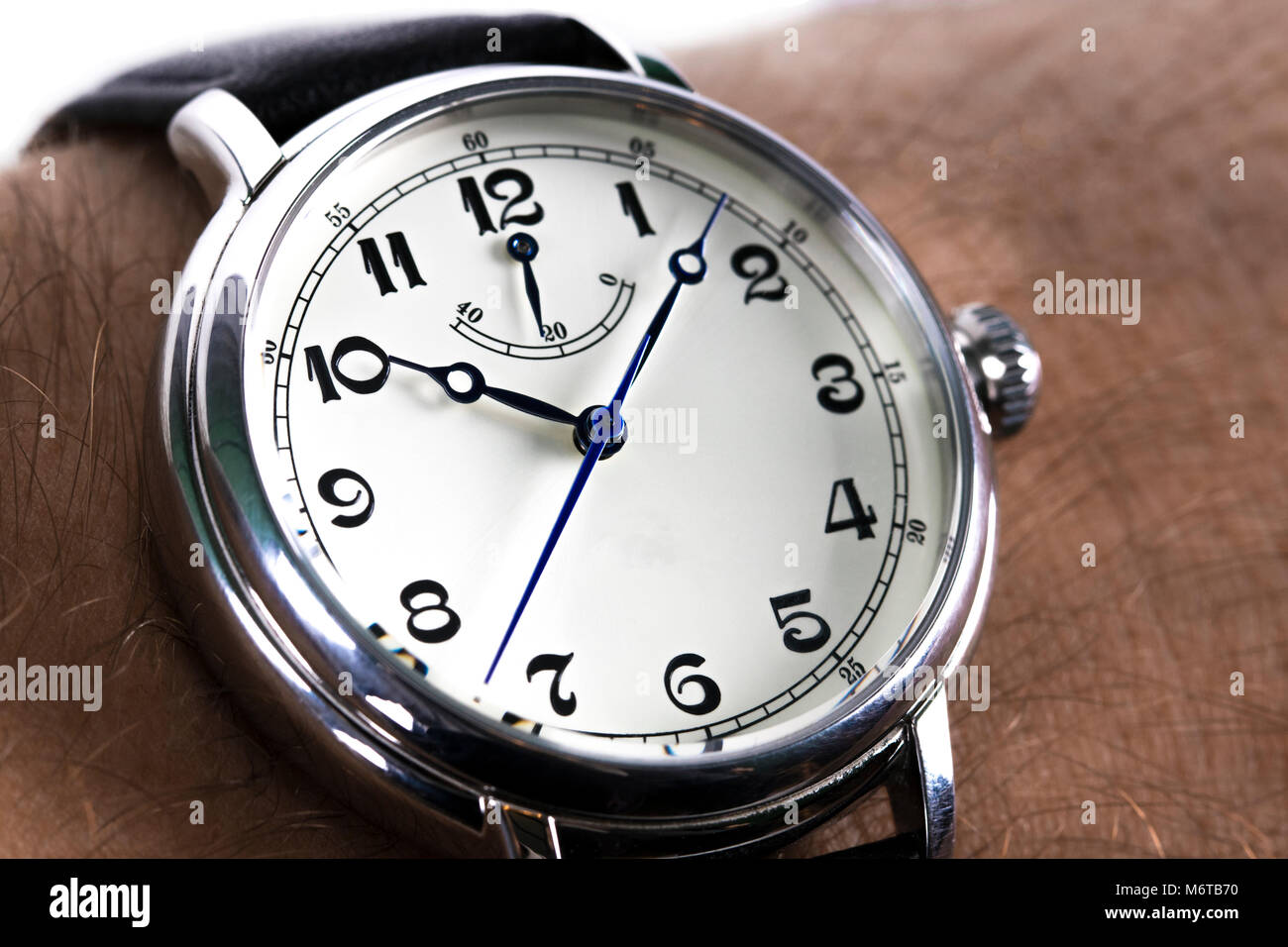 a men wearing a watch with black leather strap over a white background ...