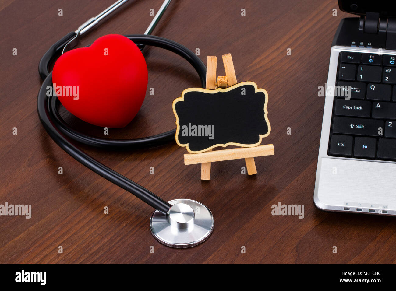 the doctor's desk with laptop, stethoscope and red heart and blackboard ...