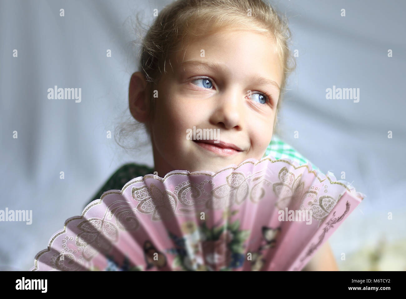 portrait - cute on bright background little girl with a fan Stock Photo ...