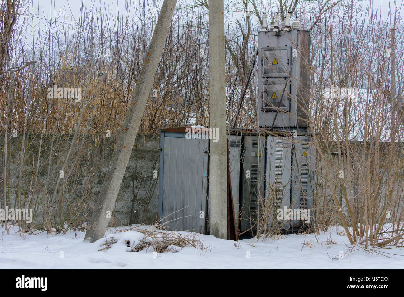 An old rusty transformer station in winter in an abandoned and ...