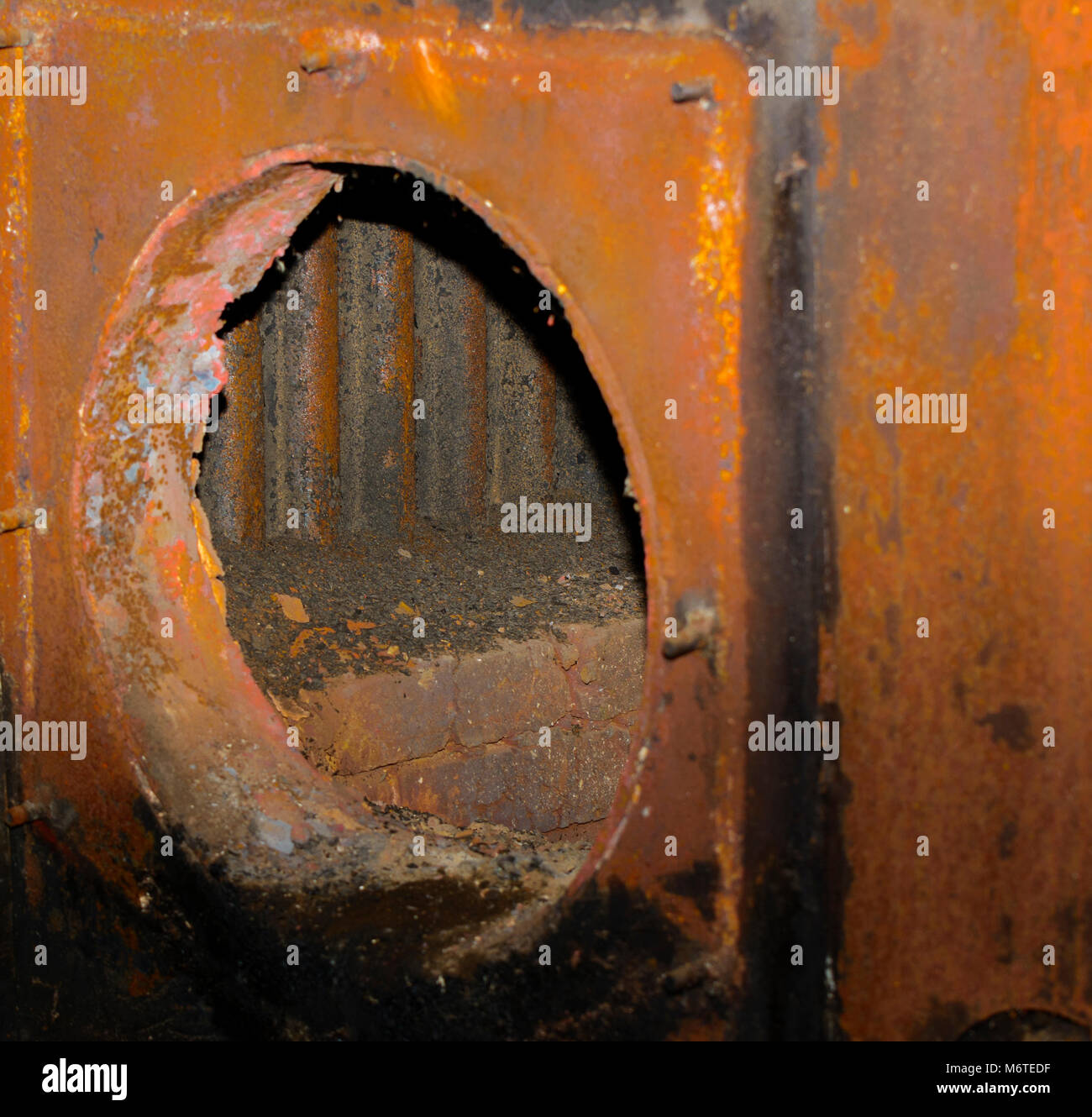 An old rusty stove for heating premises in winter in an abandoned and ...