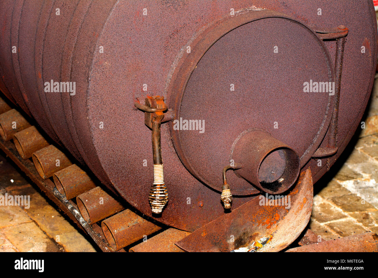 An old rusty stove for heating premises in winter in an abandoned and ...