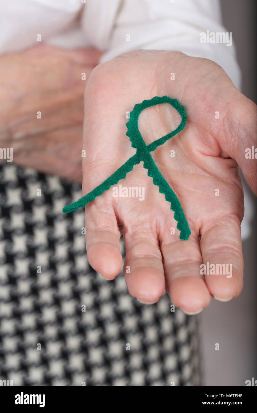 Green felt ribbon in the hand of senior Stock Photo - Alamy