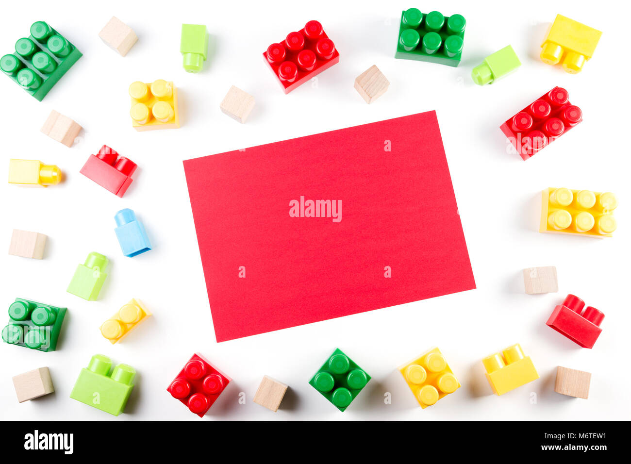 Colorful wooden cubes and plastic construction blocks with red blank ...