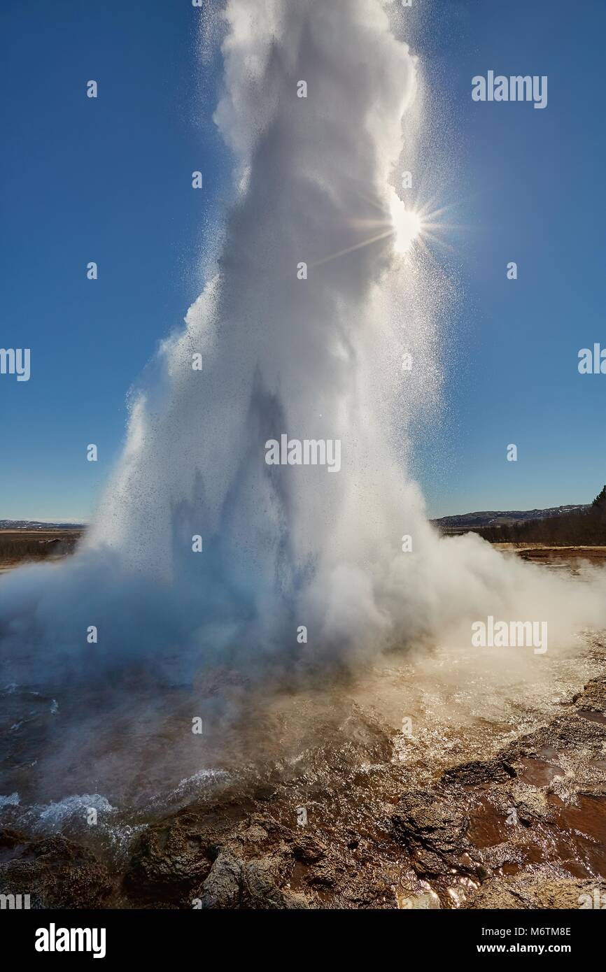Erupting geyser in sunlight Stock Photo - Alamy