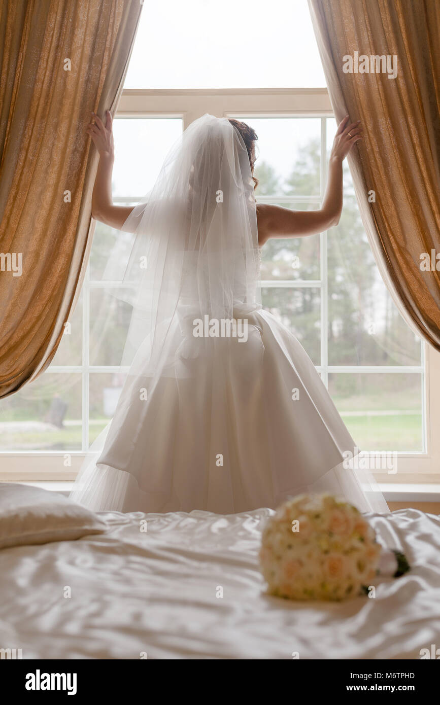 Bride looking through the window Stock Photo - Alamy