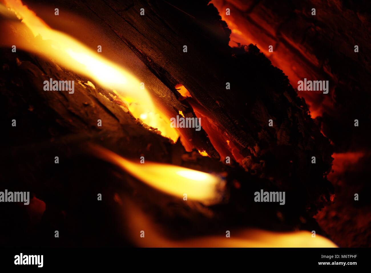 Detail view into fireplace ember wood. Glowing embers in hot red color ...