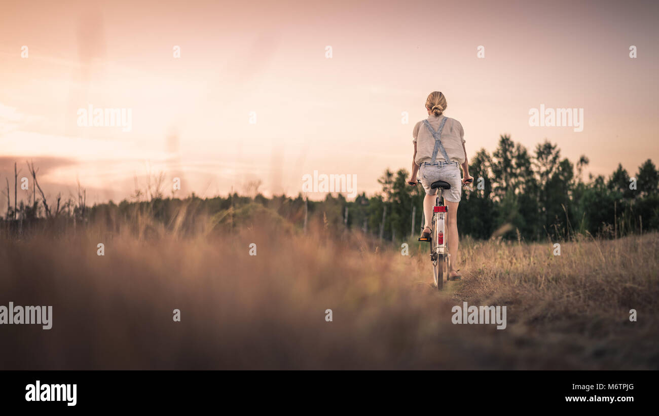 Woman riding bike bicycle village hi-res stock photography and images ...