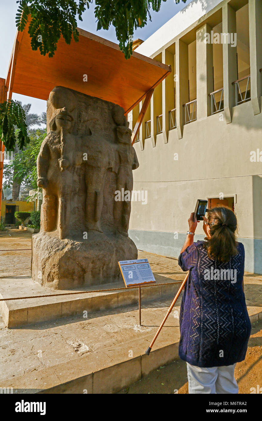 A tourist taking a photograph of The Triad of Memphis, Ptah, Sekhnet ...