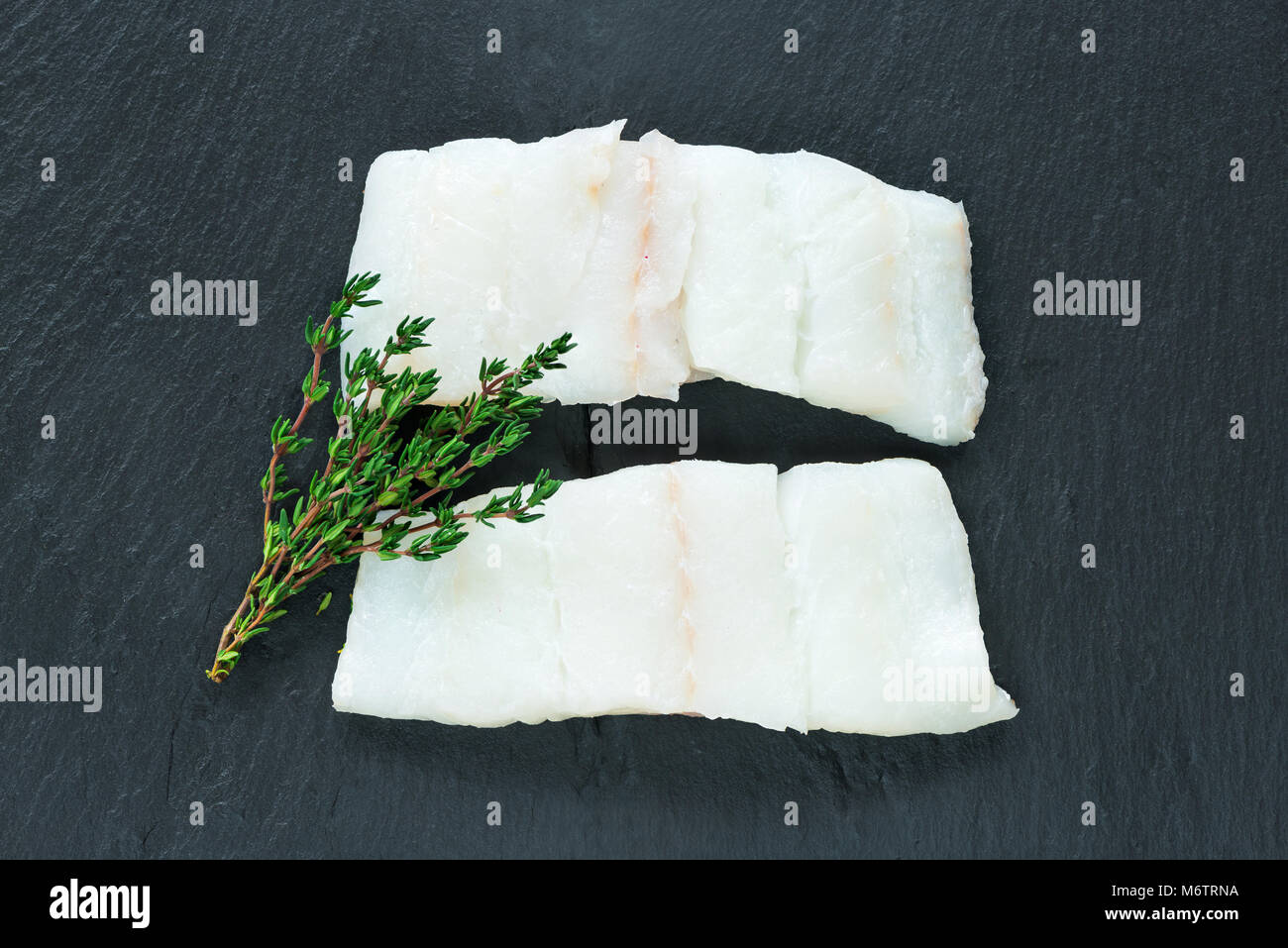 Raw haddock fillets on black board - top view Stock Photo - Alamy