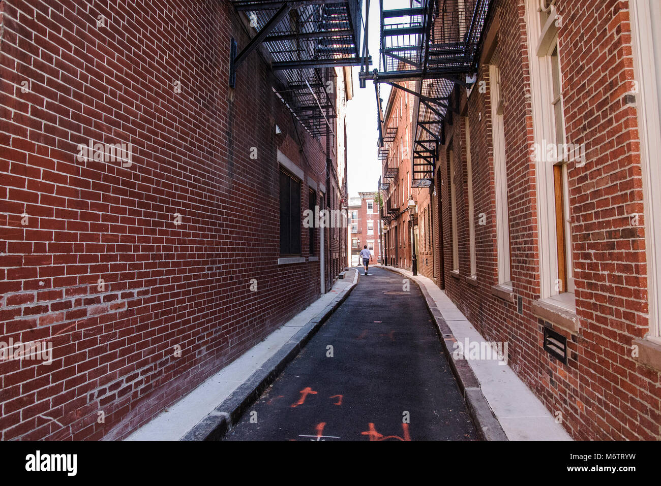 A person walking in an alley way in boston Stock Photo - Alamy