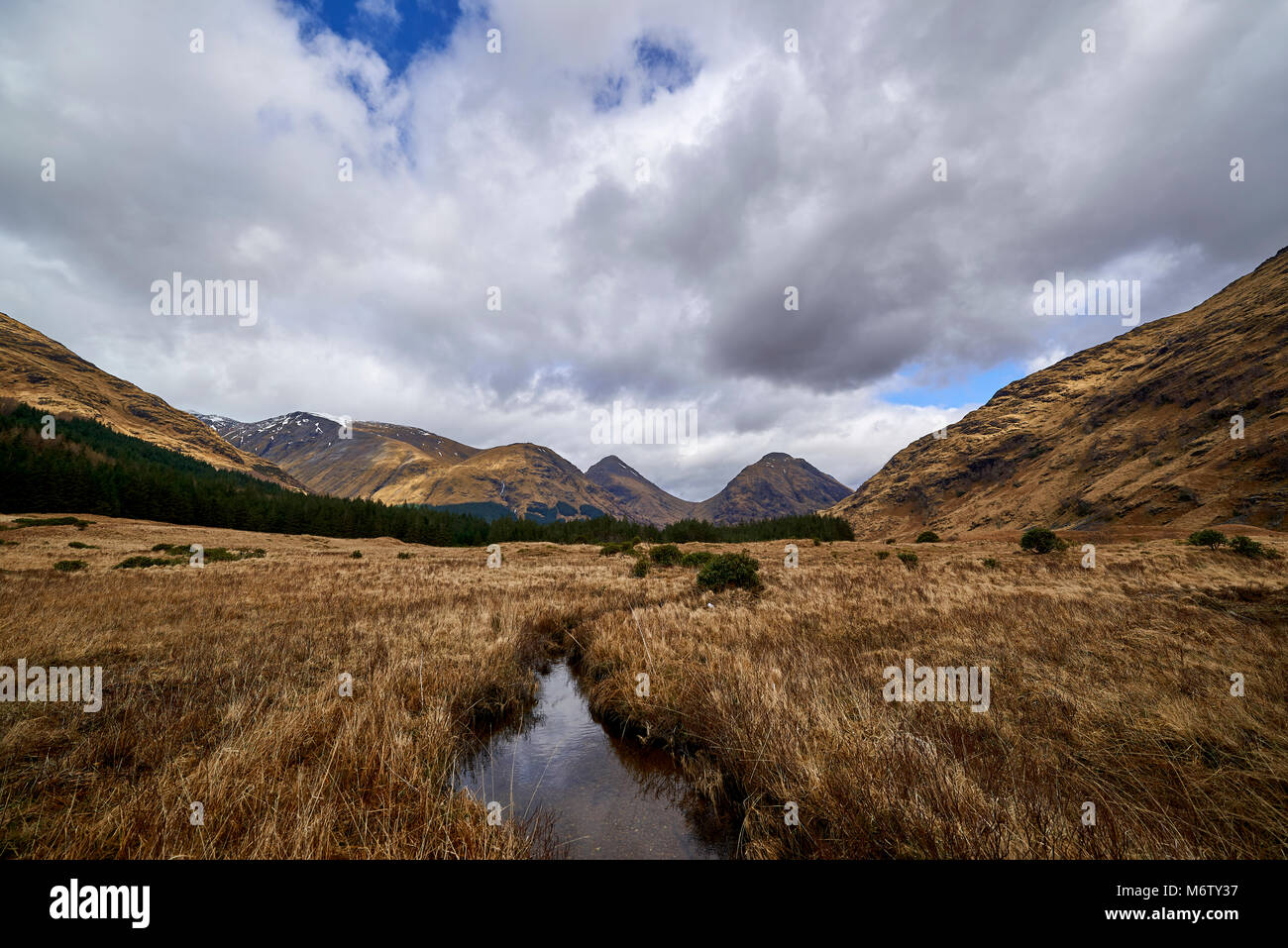 A small stream runs along the valley floor in Glen Etive Stock Photo ...