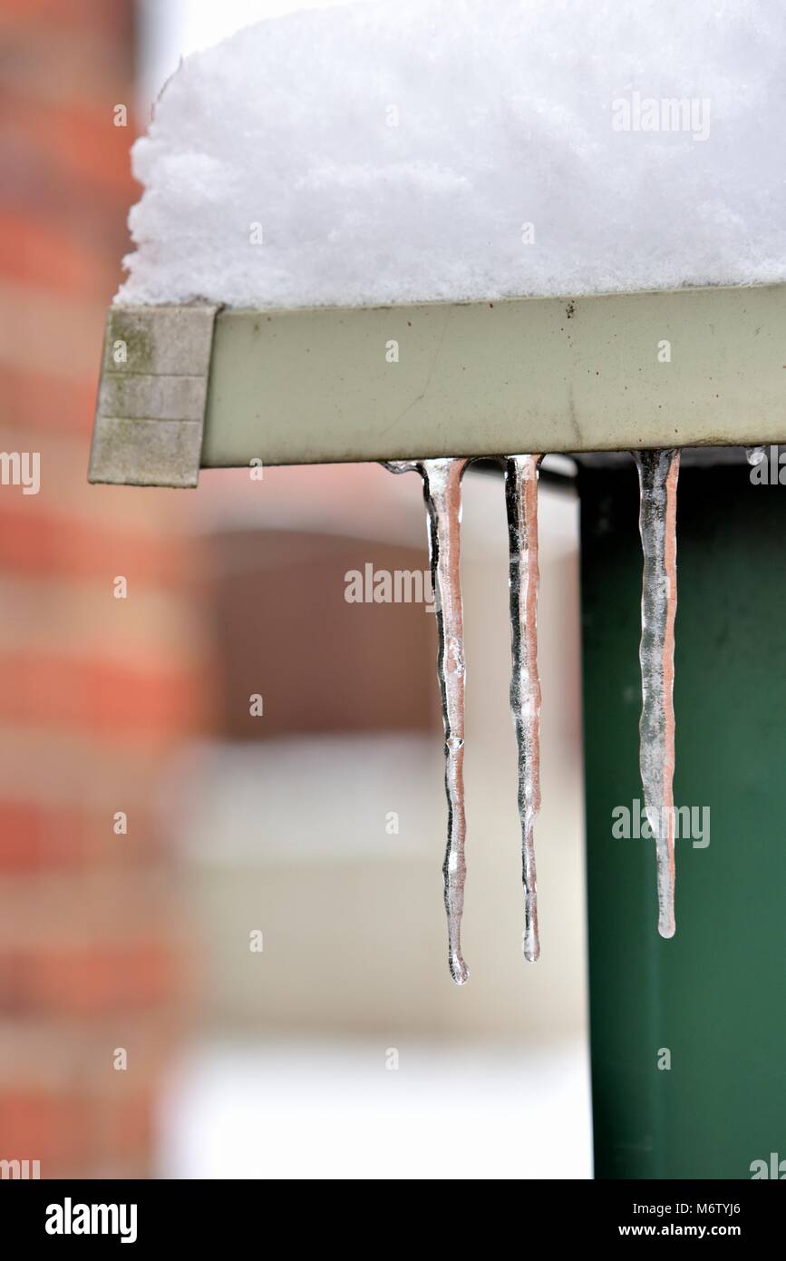 Icicles forming on a garden shed roof uk Stock Photo - Alamy