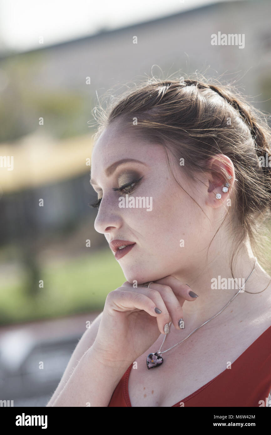 Outdoor close up portrait of a young woman with dramatic eye makeup and ...