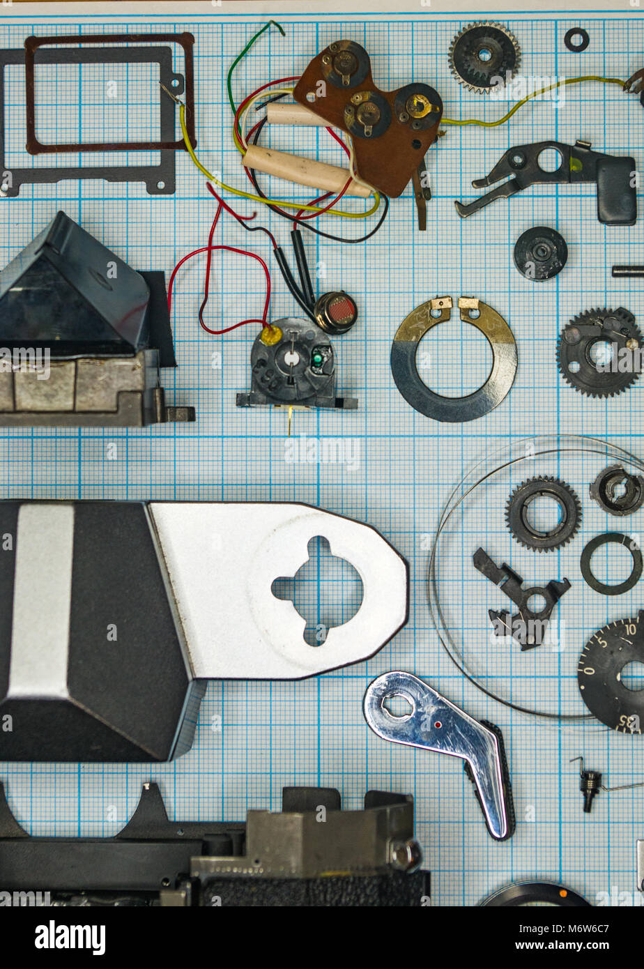 parts are completely disassembled old retro film SLR camera on graph ...