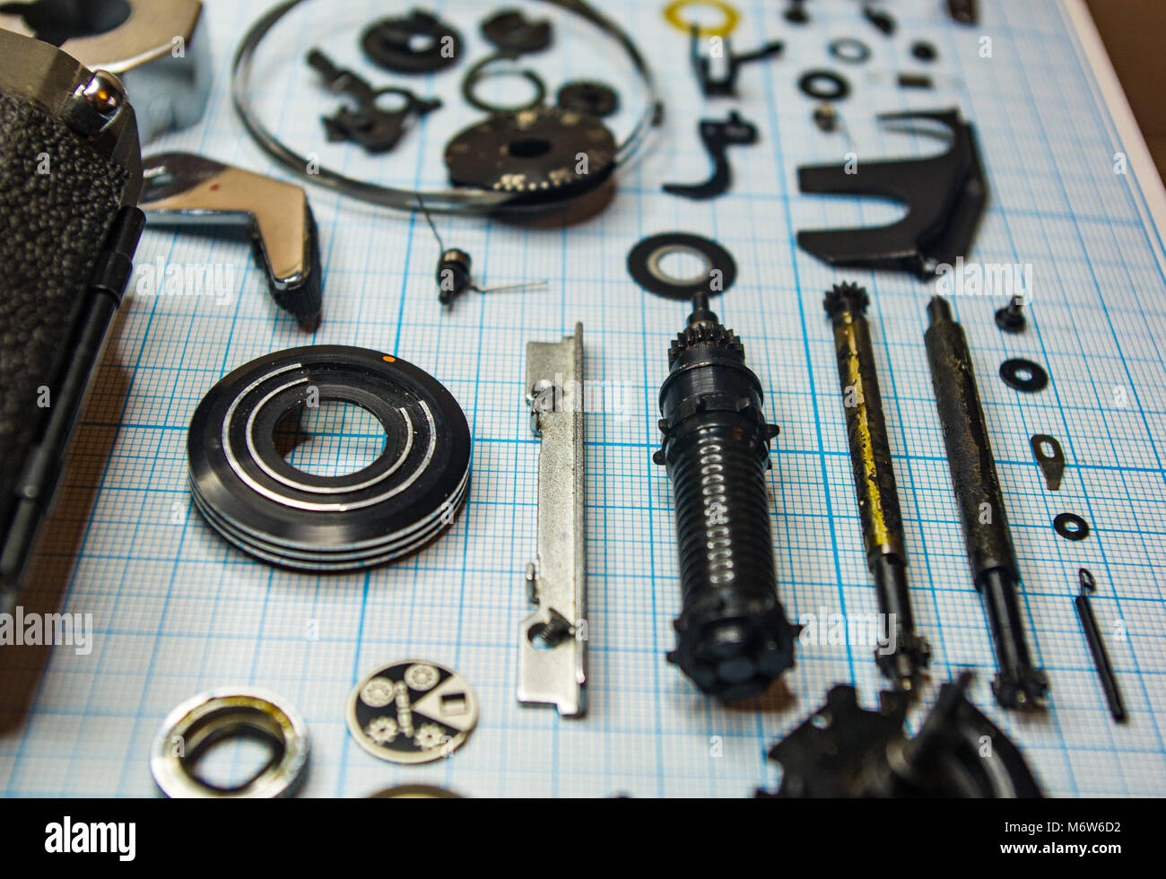 parts are completely disassembled old retro film SLR camera on graph ...