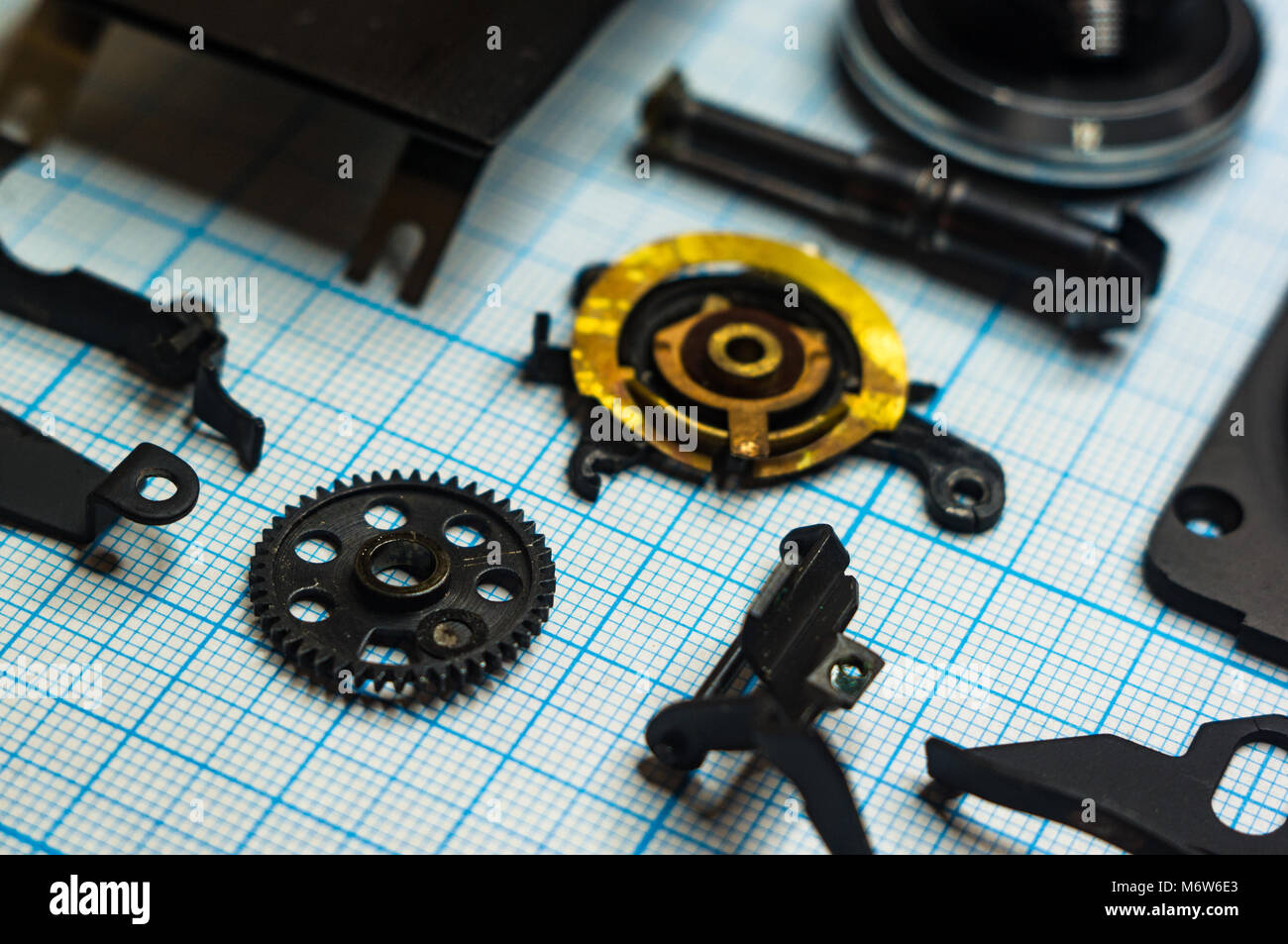 parts are completely disassembled old retro film SLR camera on graph ...