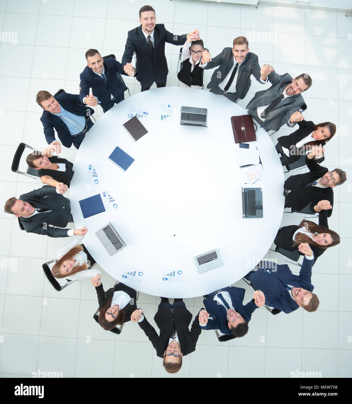 large business team sitting at the round table and raising his hands up ...